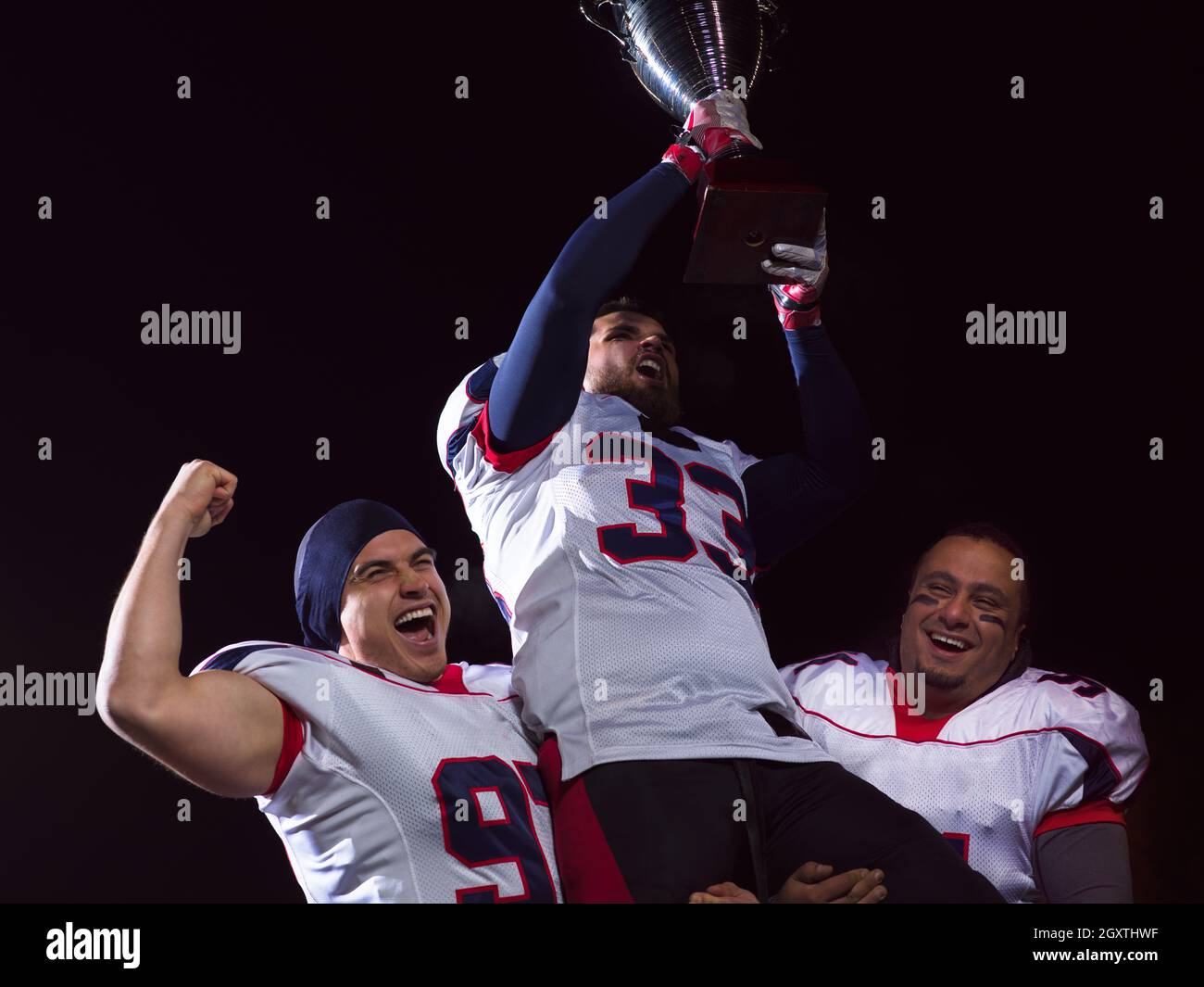 happy american football team with trophy celebrating victory on night ...
