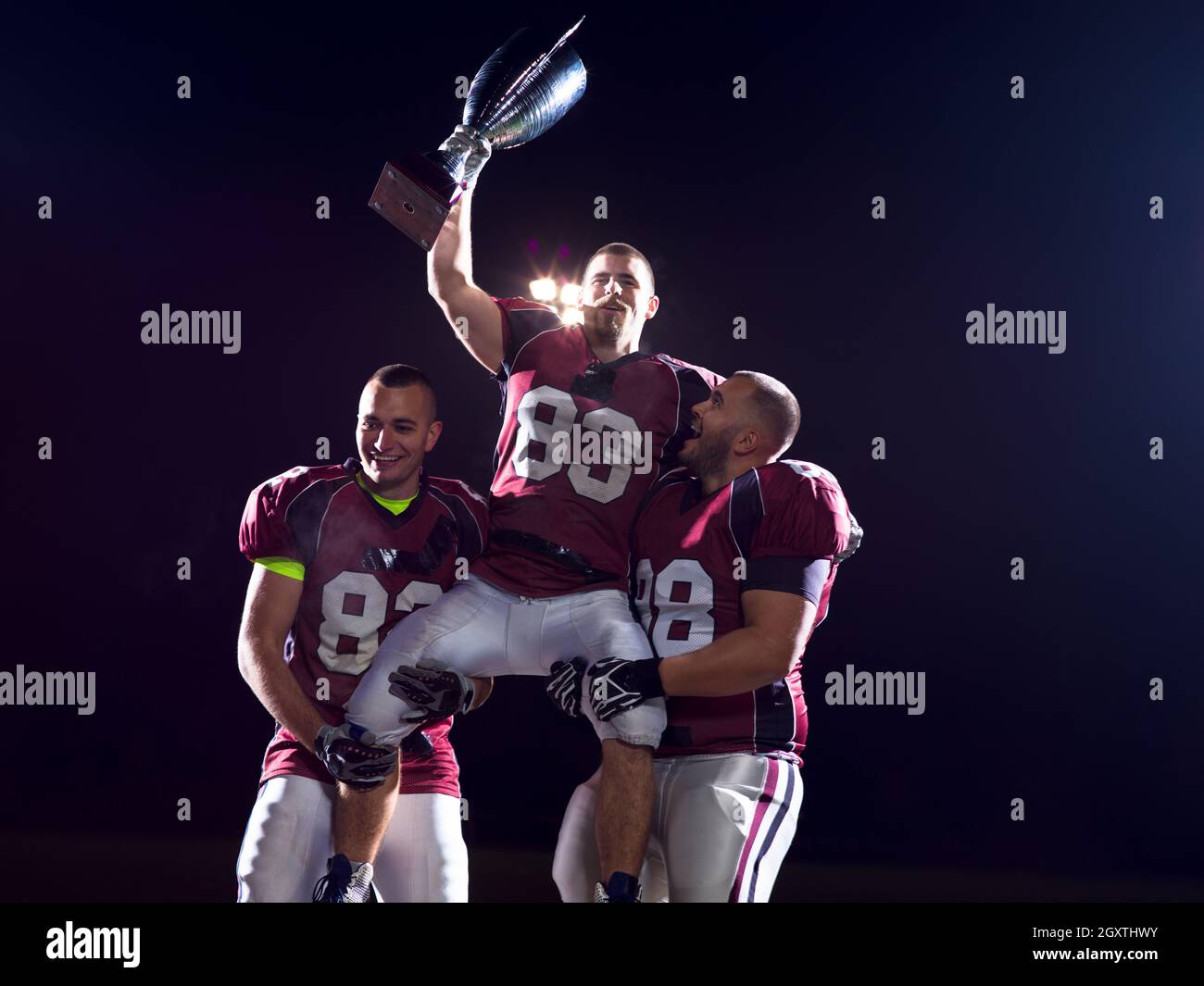 happy american football team with trophy celebrating victory on night ...