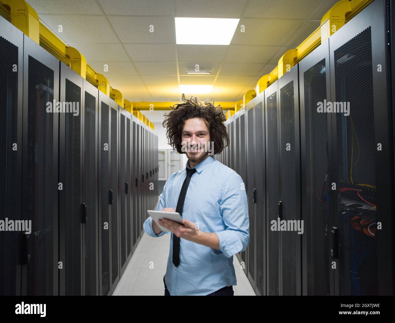 Male IT engineer working on a tablet computer in server room at modern ...