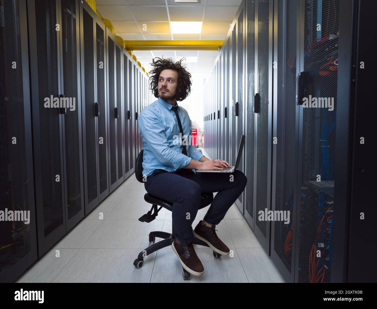 Male IT engineer working on a laptop in server room at modern data ...