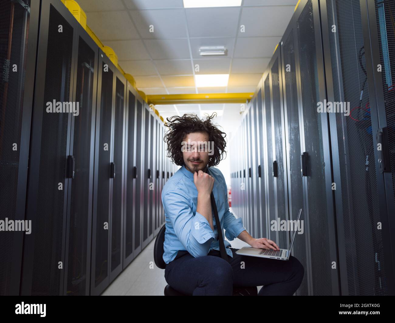 Male IT engineer working on a laptop in server room at modern data ...