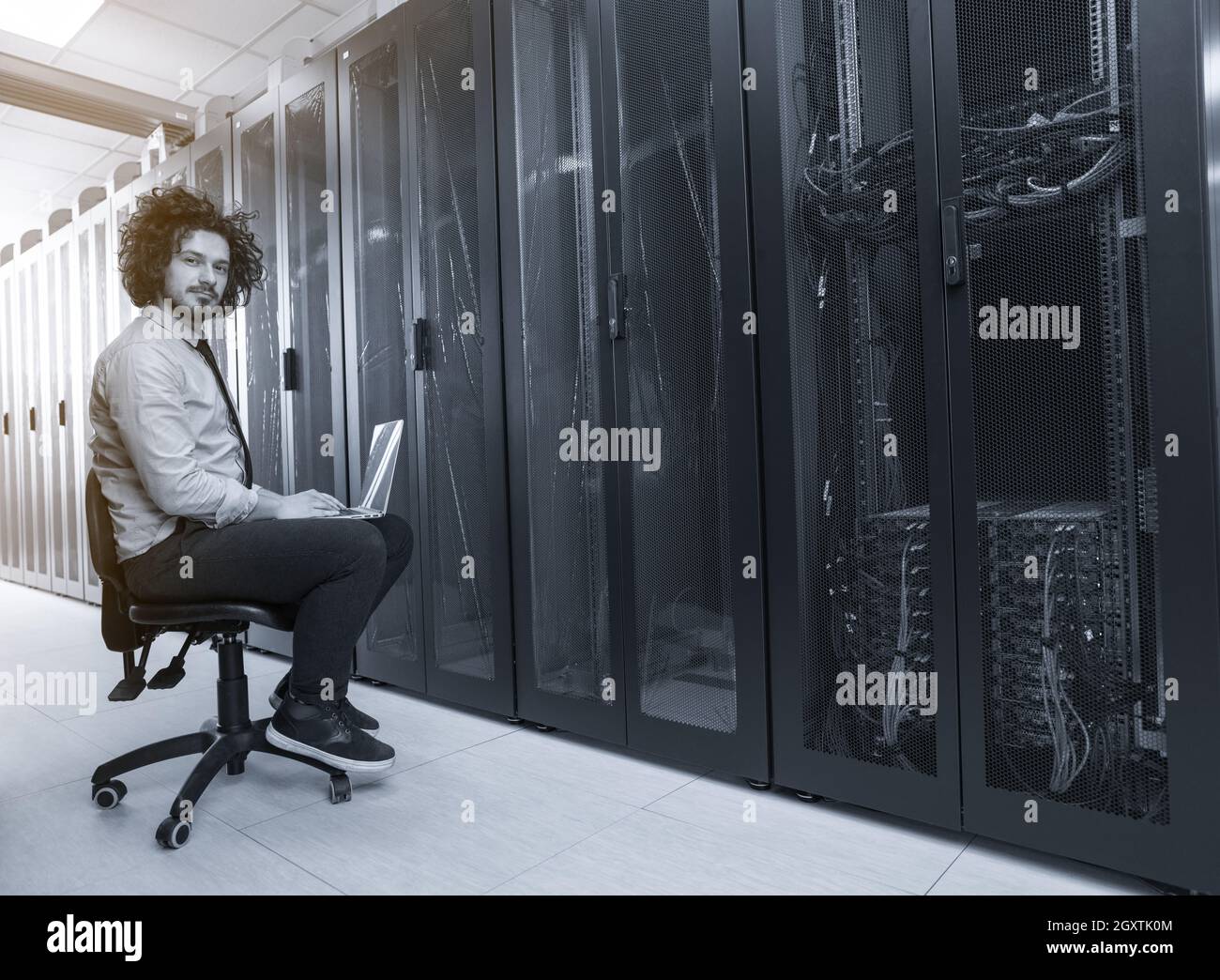 Male IT engineer working on a laptop in server room at modern data ...