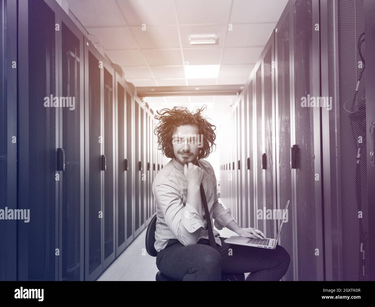 Male IT engineer working on a laptop in server room at modern data ...