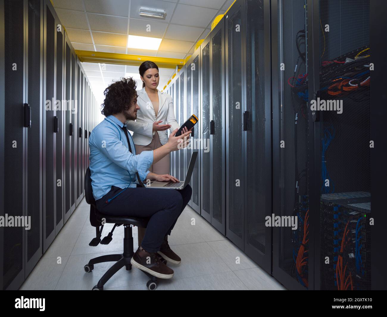 Team of young technicians working together on servers at the data ...