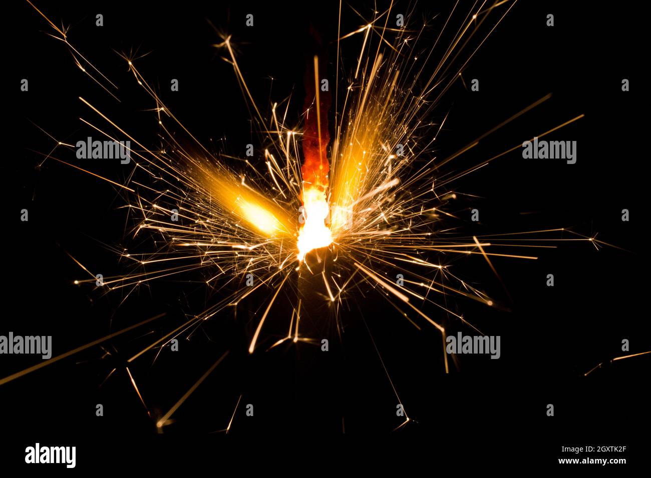 Lit sparkler shooting off sparks in the night Stock Photo - Alamy
