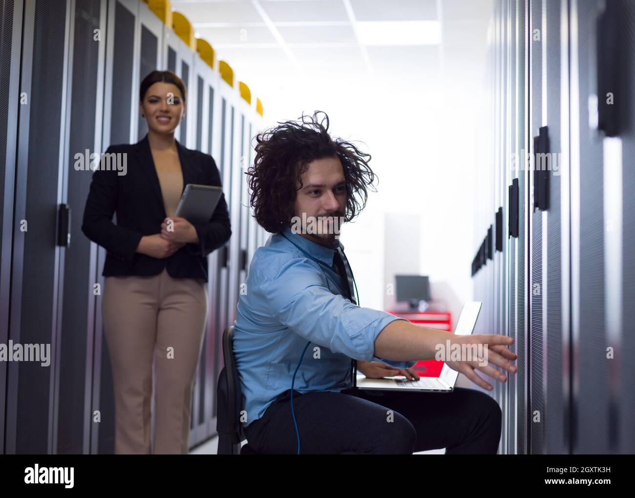 Team of young technicians working together on servers at the data ...
