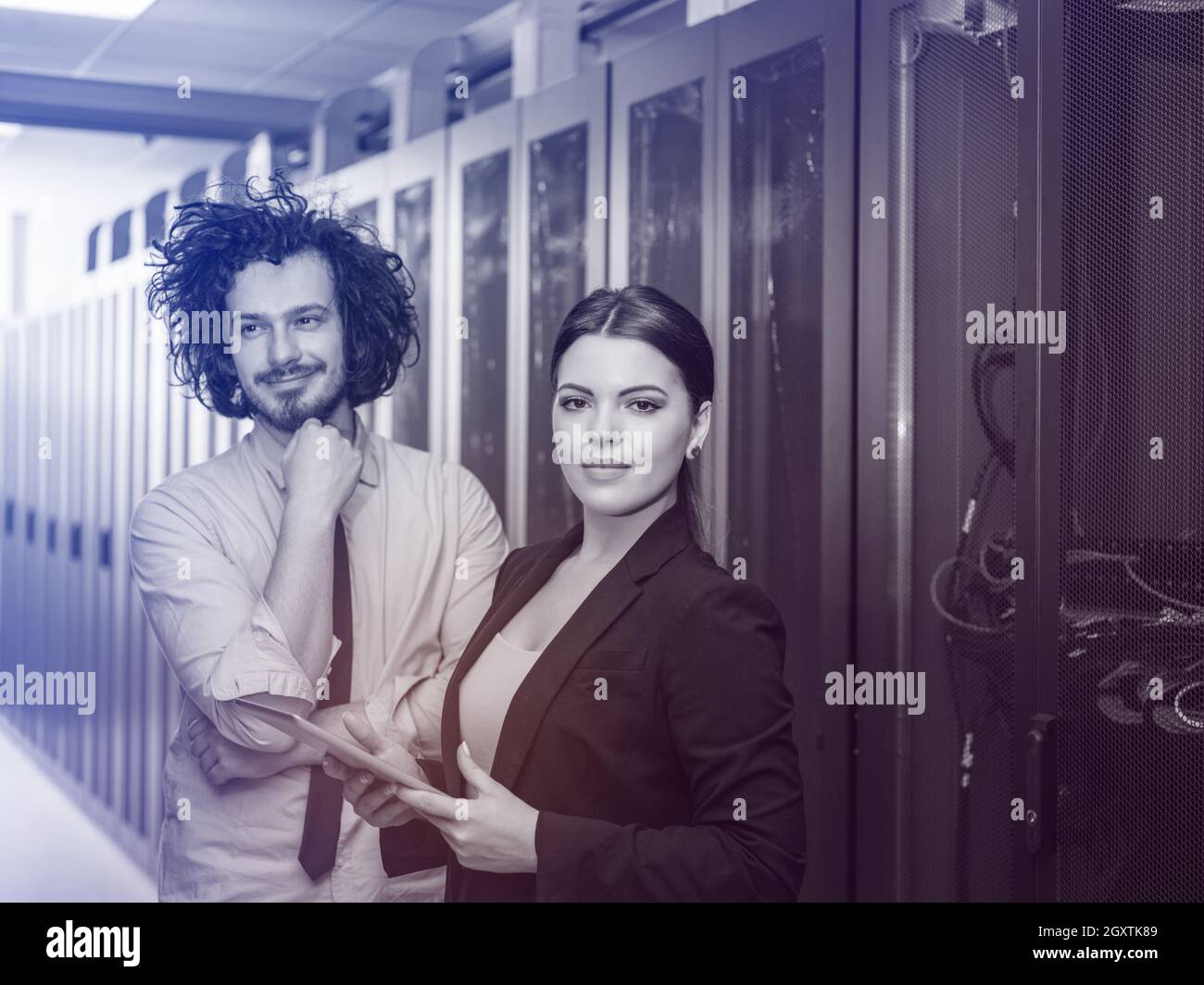Young IT engineer showing working data center server room to female ...