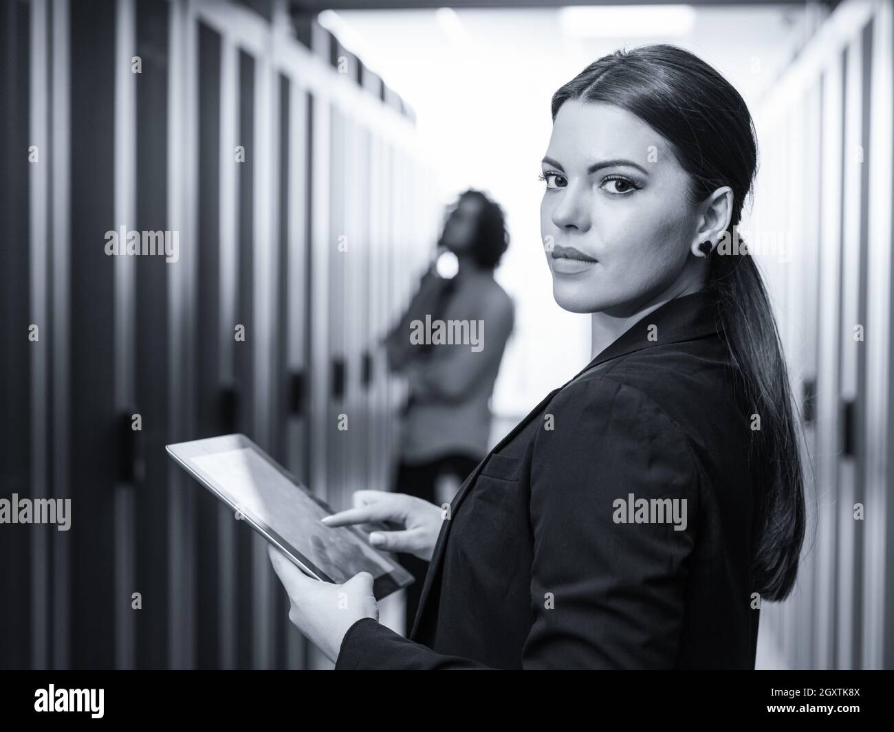 Female IT engineer working on a tablet computer in server room at ...