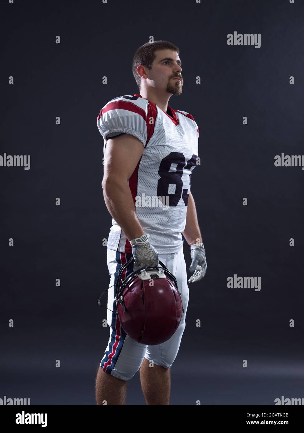 Portrait of a strong muscular American Football Player isolated on gray ...