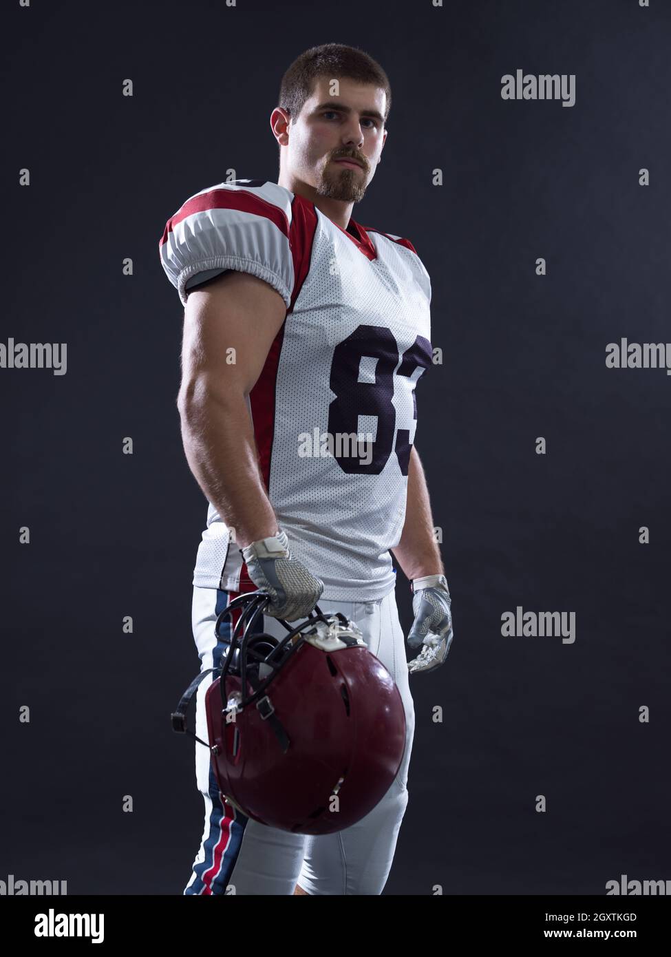 Portrait of a strong muscular American Football Player isolated on gray ...