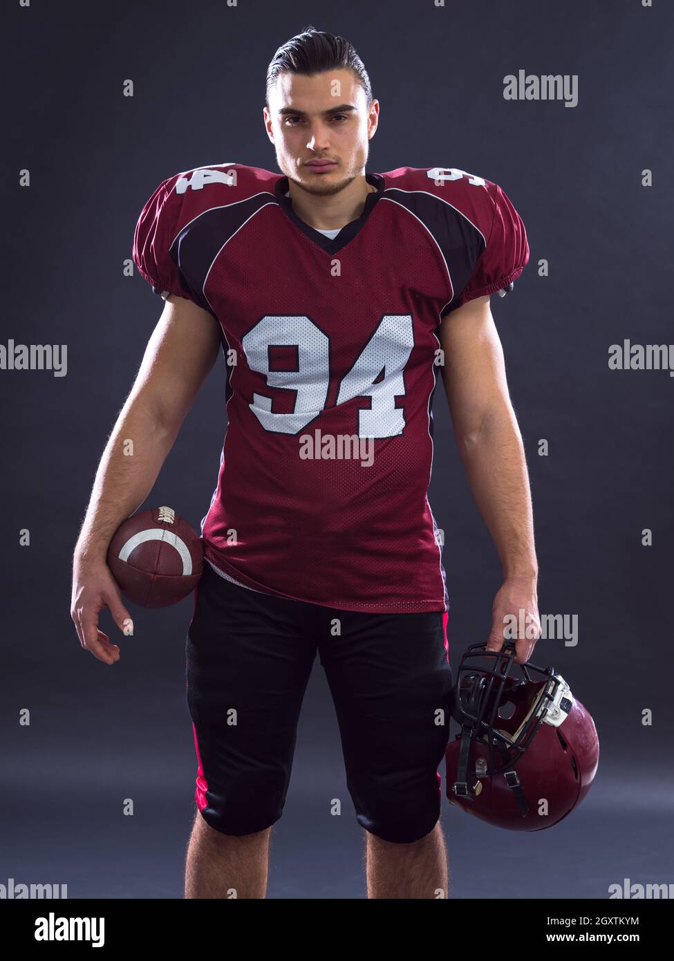 Portrait of a strong muscular American Football Player isolated on gray ...