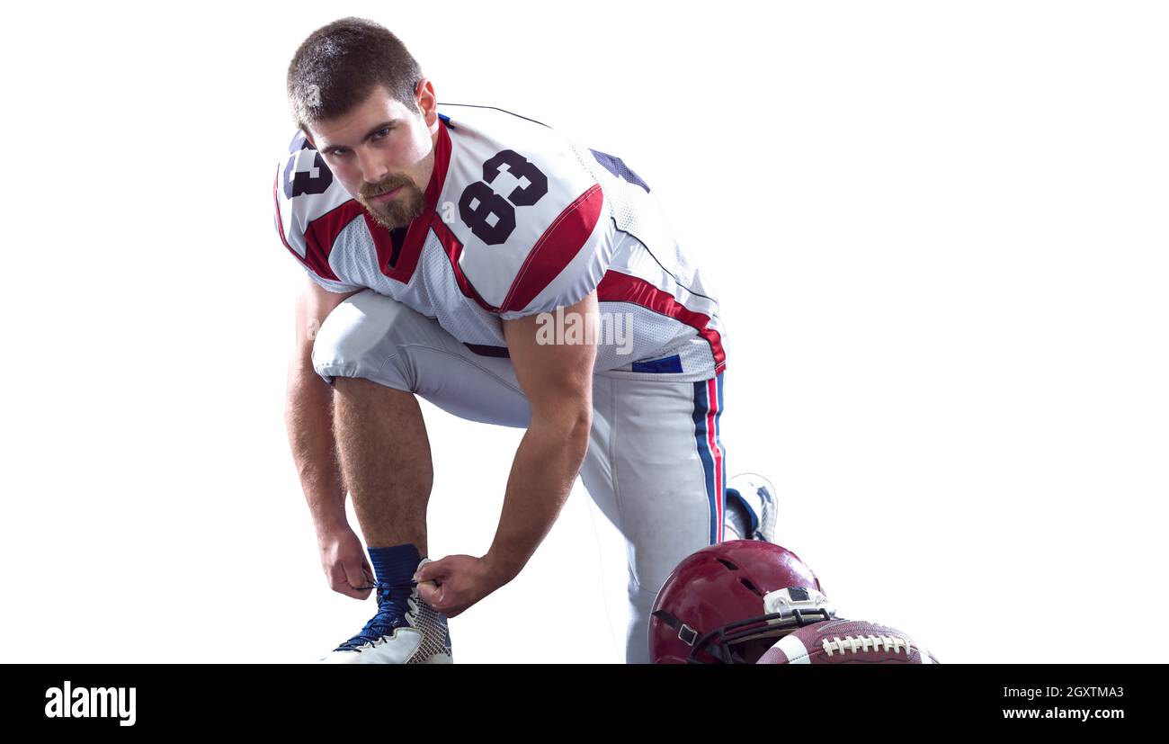 strong muscular American Football Player tie his shoe laces isolated on ...
