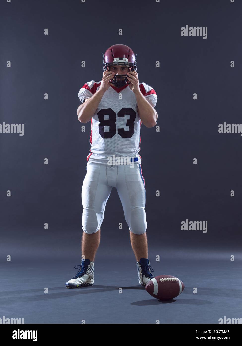 Portrait of a strong muscular American Football Player isolated on gray ...