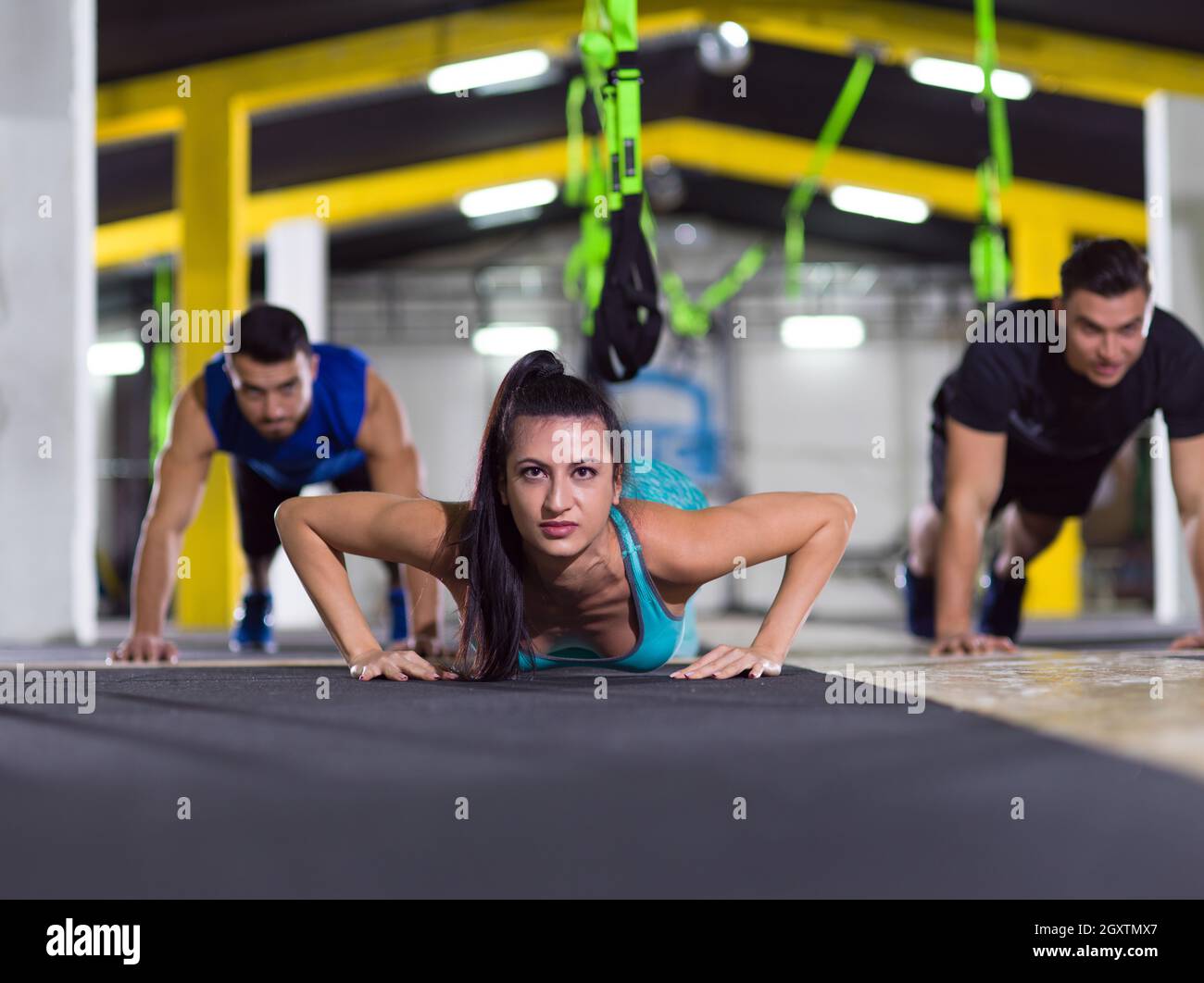 group of young healthy people doing pushups at crossfitness gym Stock ...