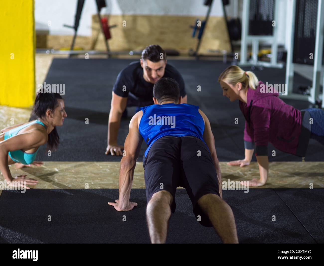 group of young healthy people doing pushups at crossfitness gym Stock ...