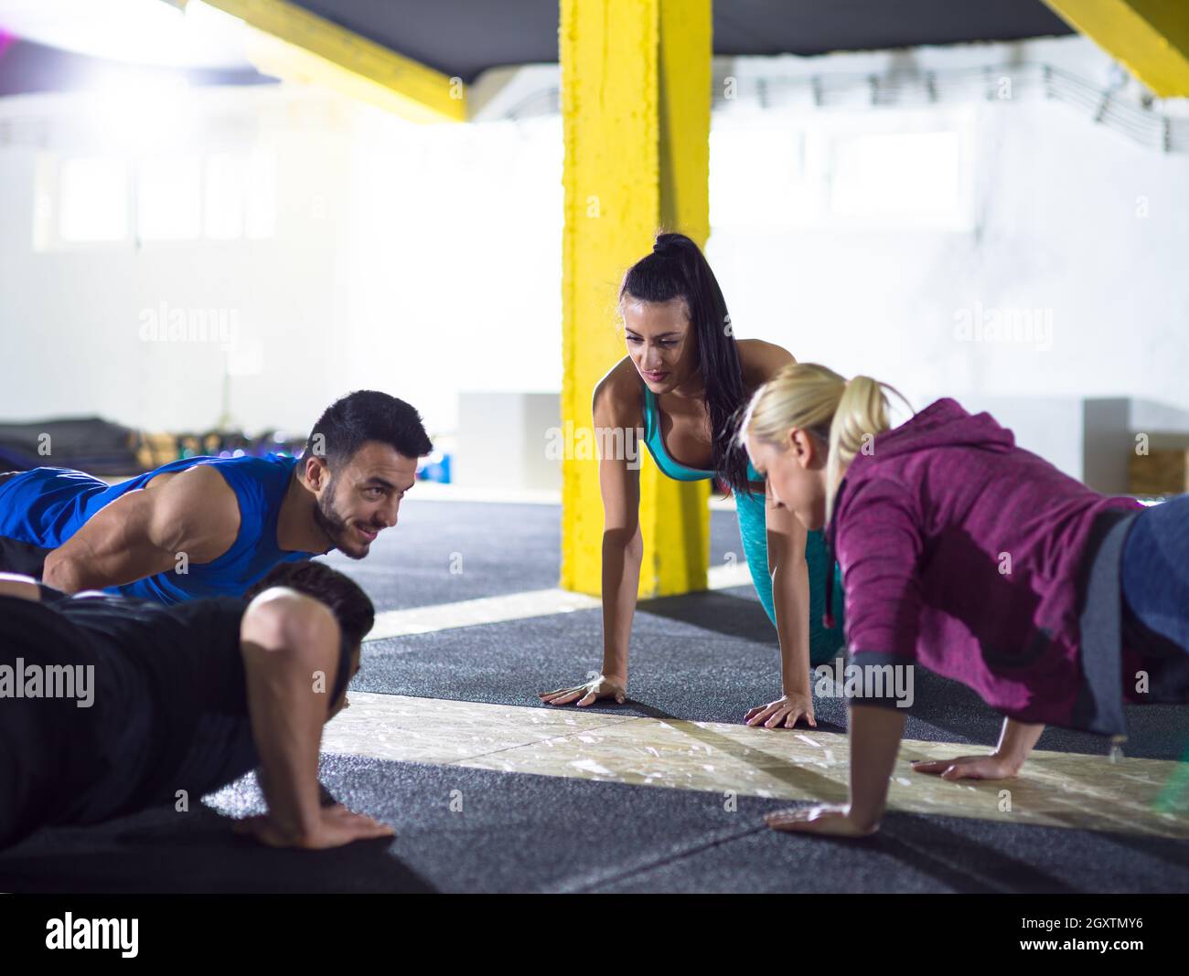 group of young healthy people doing pushups at crossfitness gym Stock ...