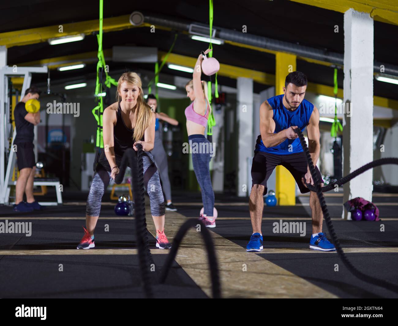 young fit sports couple working out in functional training gym doing ...