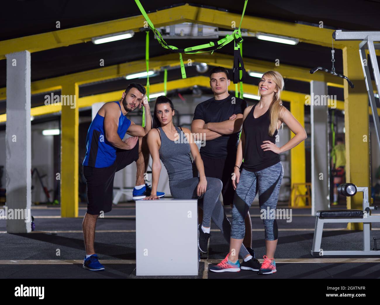 portrait of young healthy athletic people training jumping on fit box ...