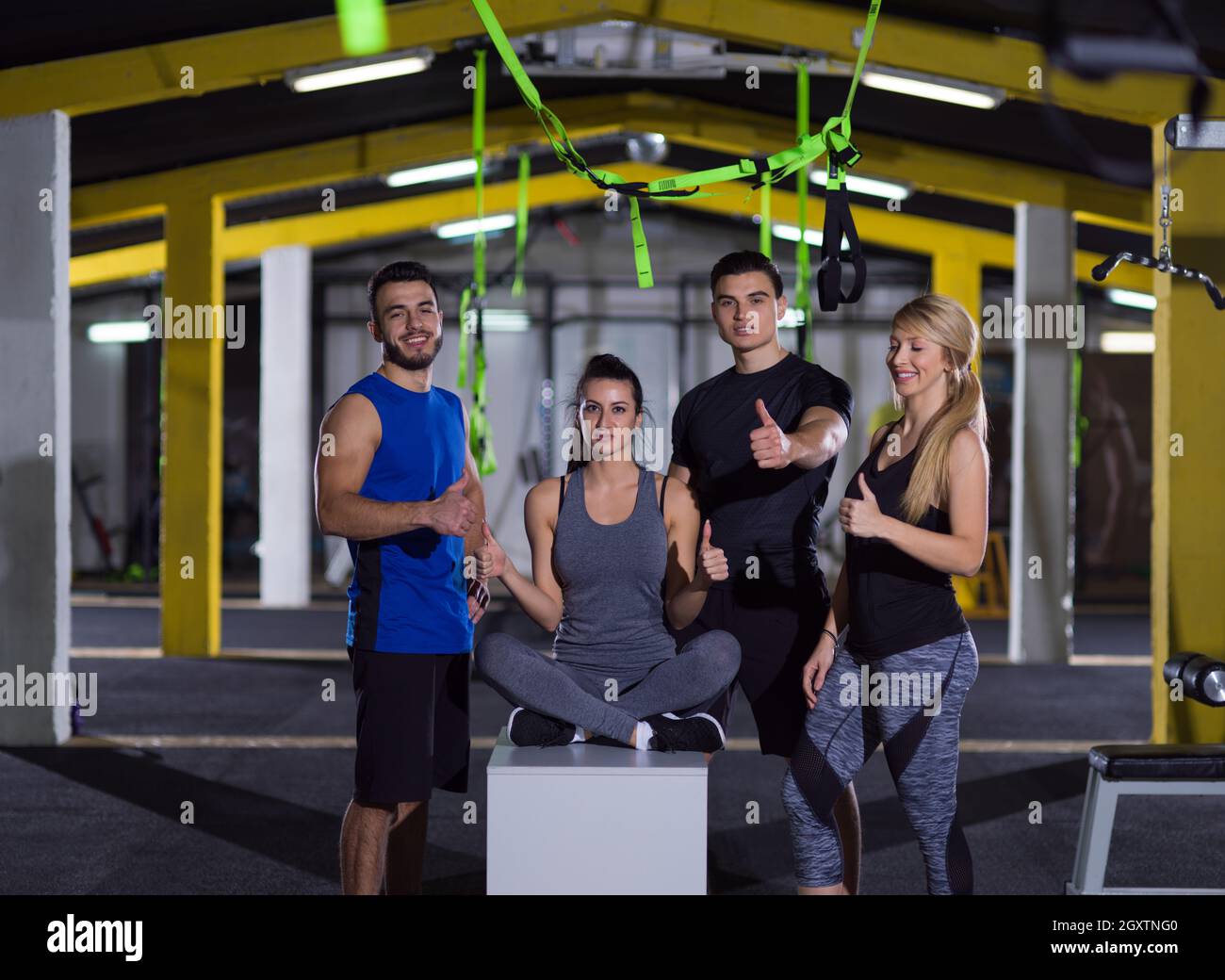 portrait of young healthy athletic people training jumping on fit box ...