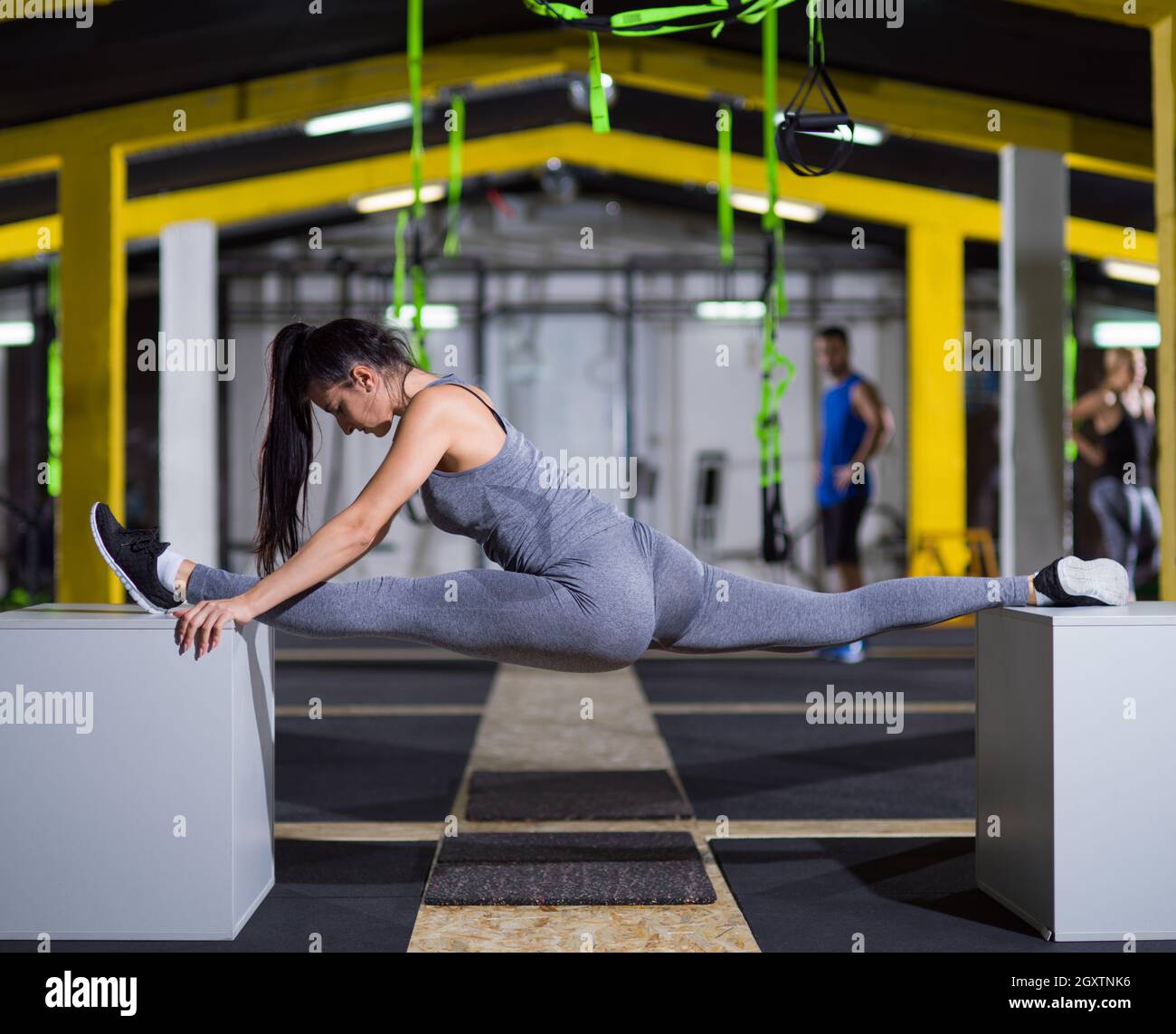 young athletic woman doing gymnastic exercise between two fit boxes at ...