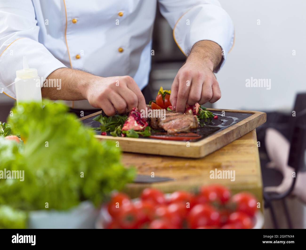 closeup of Chef hands in hotel or restaurant kitchen serving beef steak ...