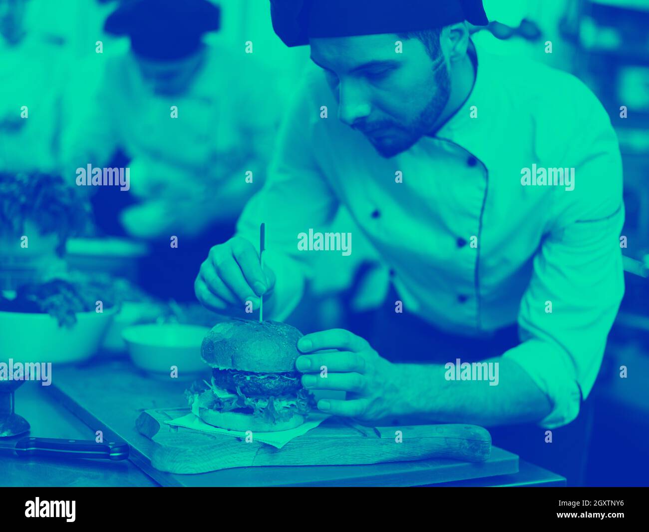 master chef putting toothpick on a burger in restaurant kitchen Stock ...