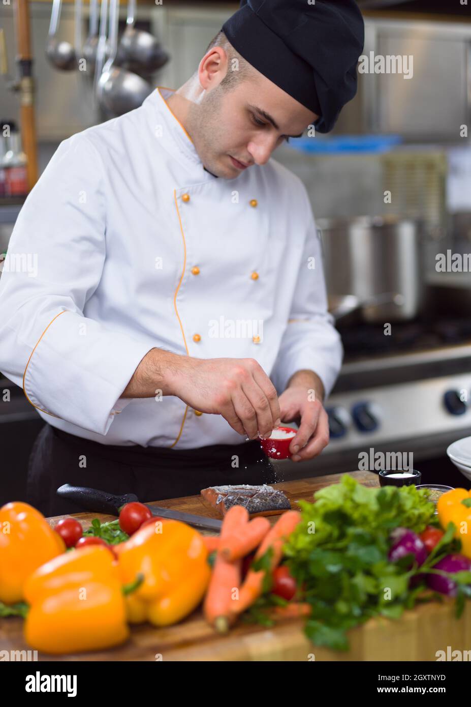 Chef hands preparing marinated Salmon fish fillet for frying in a ...