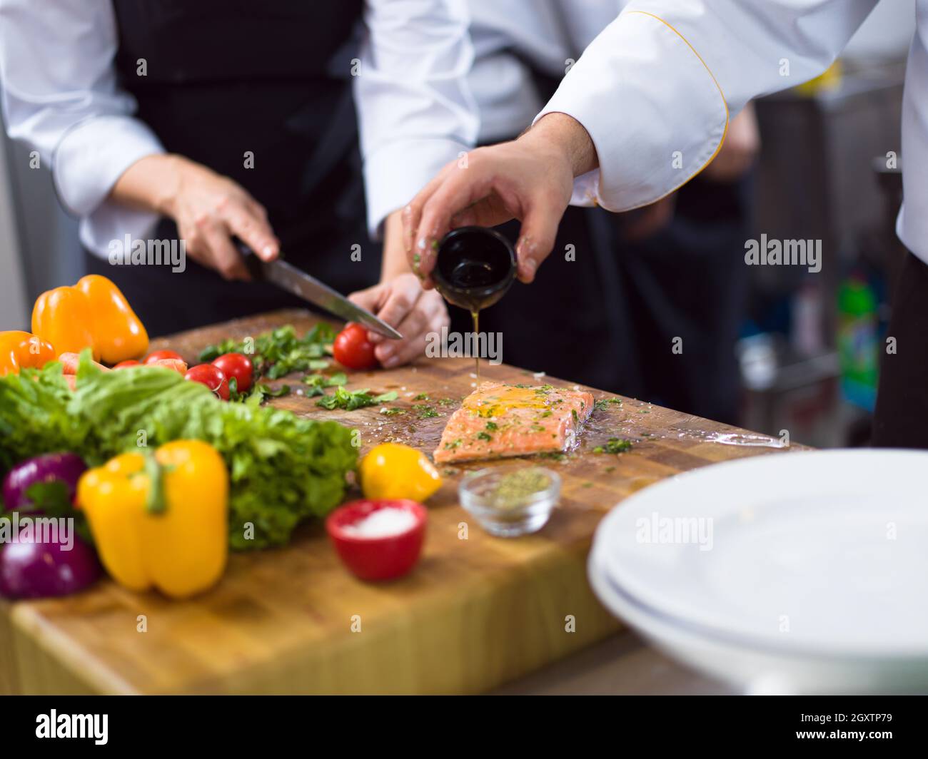 Chef hands preparing marinated Salmon fish fillet for frying in a ...