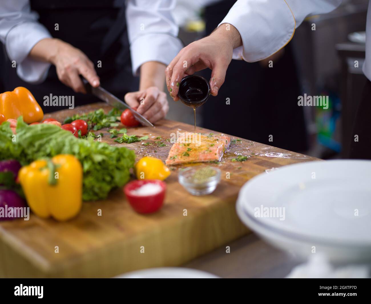 Chef hands preparing marinated Salmon fish fillet for frying in a ...