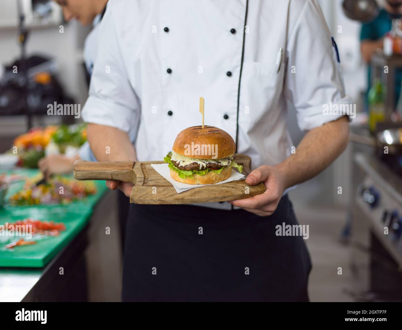 master chef putting toothpick on a burger in restaurant kitchen Stock ...