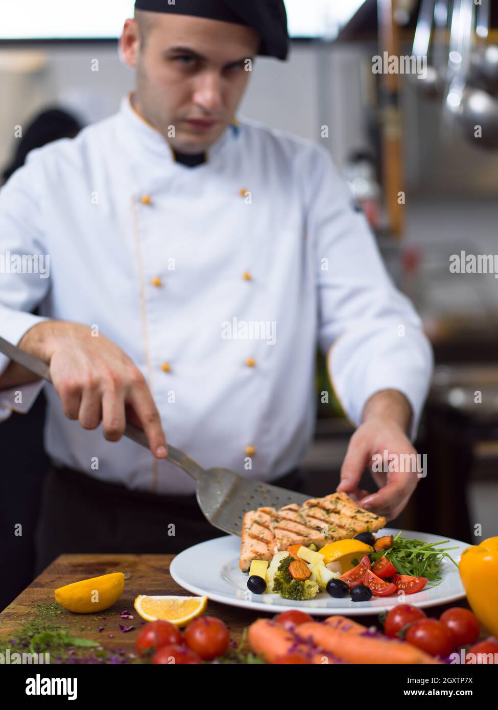 cook chef decorating garnishing prepared meal dish on the plate in ...