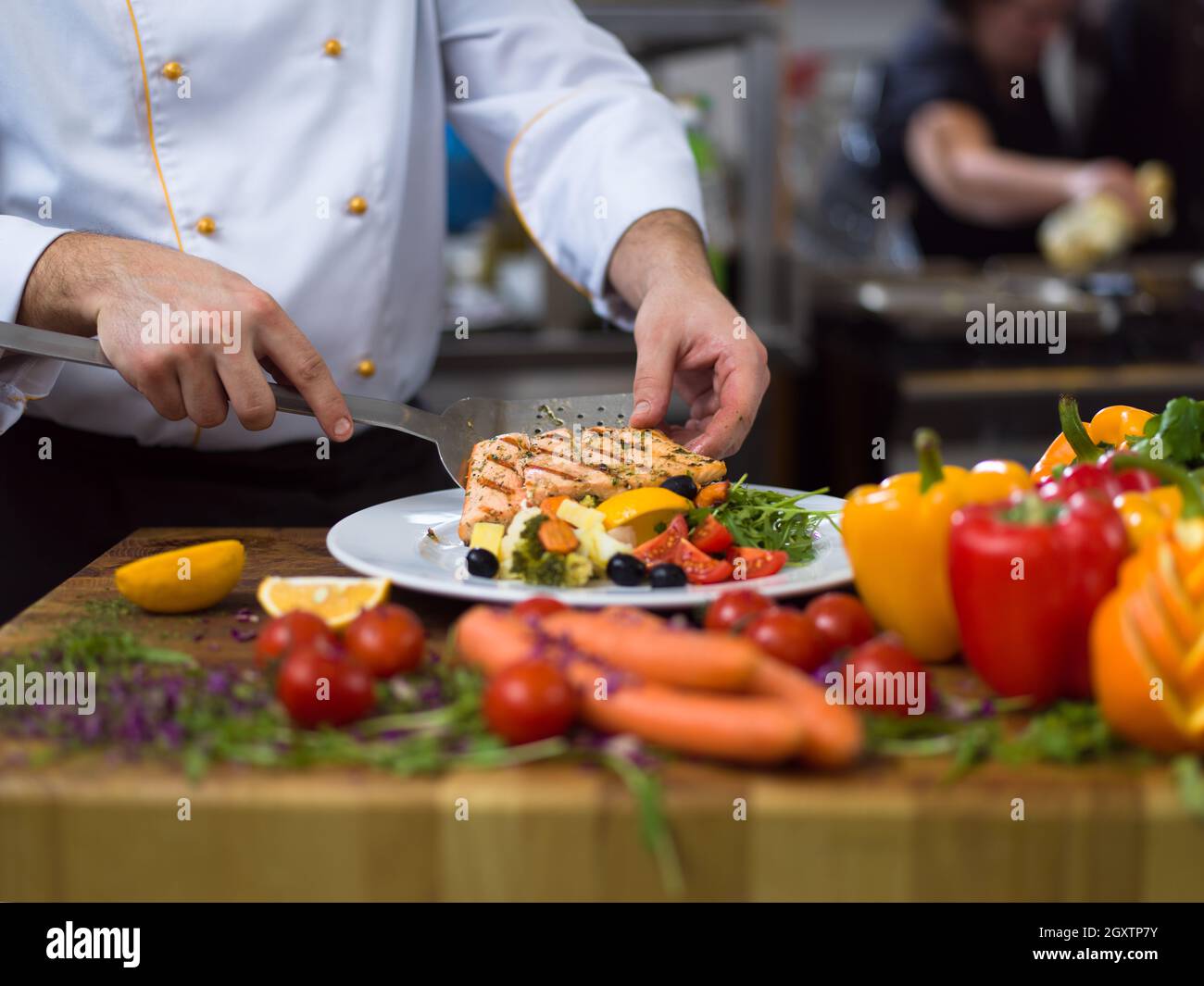 cook chef decorating garnishing prepared meal dish on the plate in ...