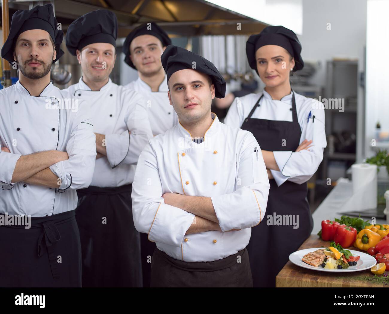 Portrait of group chefs standing together in commercial kitchen at ...