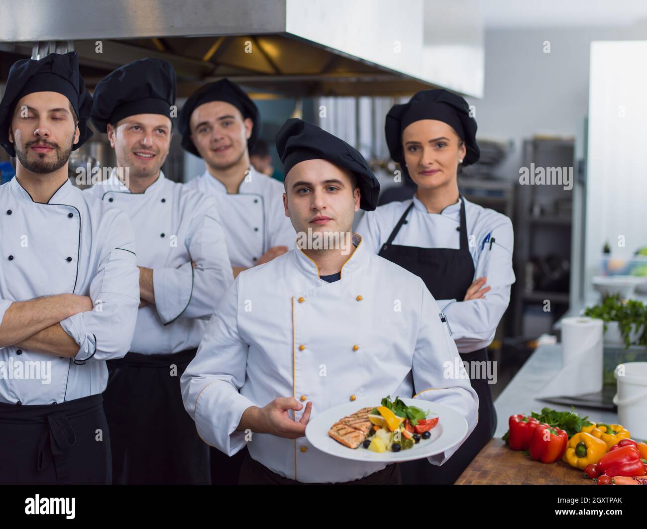 Portrait of group chefs standing together in commercial kitchen at ...