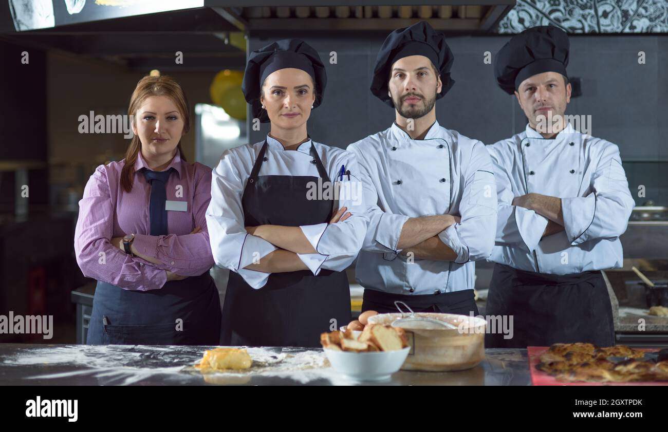Portrait of group chefs standing together in commercial kitchen at ...