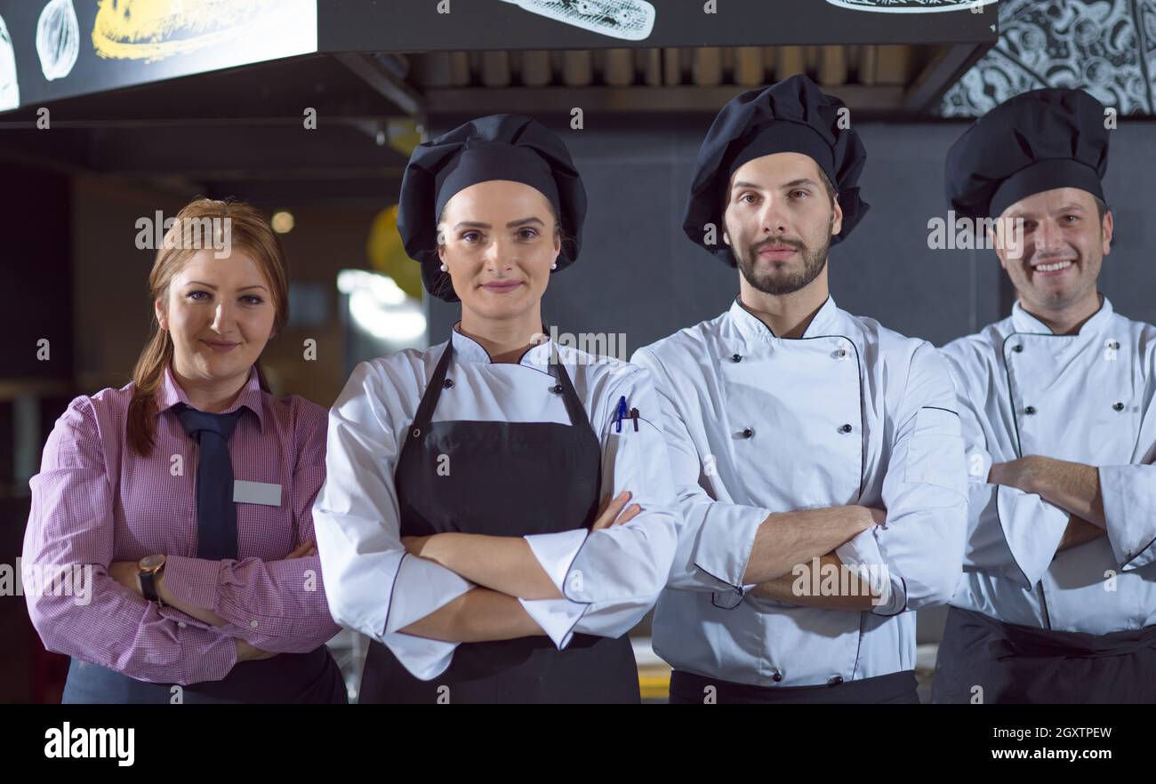 Portrait of group chefs standing together in commercial kitchen at ...