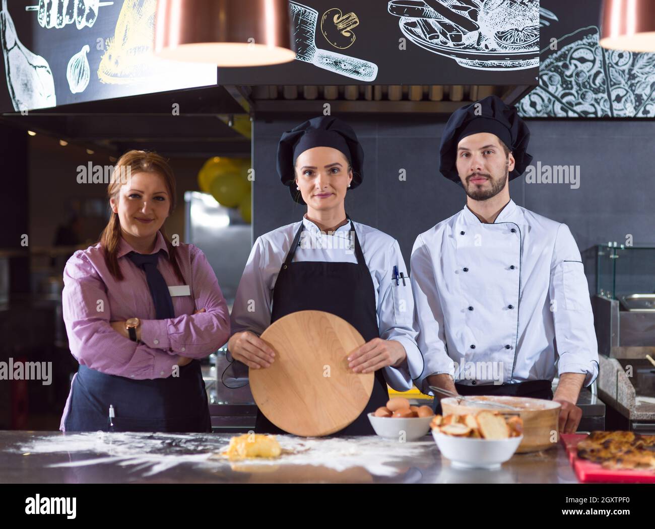 Portrait of group chefs standing together in commercial kitchen at ...