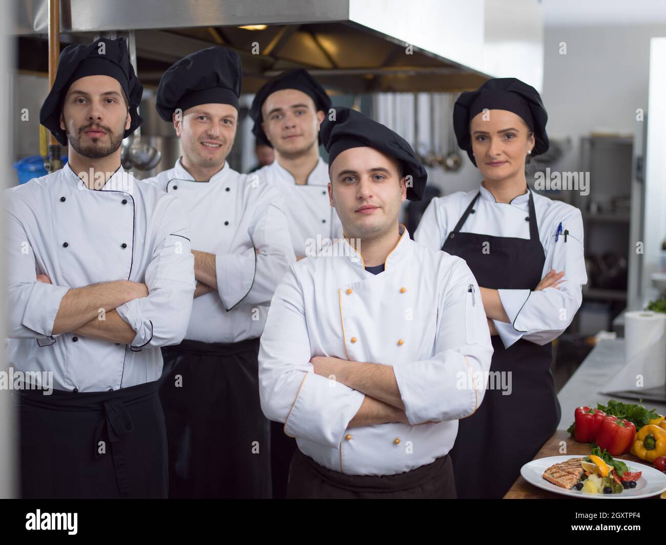 Portrait of group chefs standing together in commercial kitchen at ...