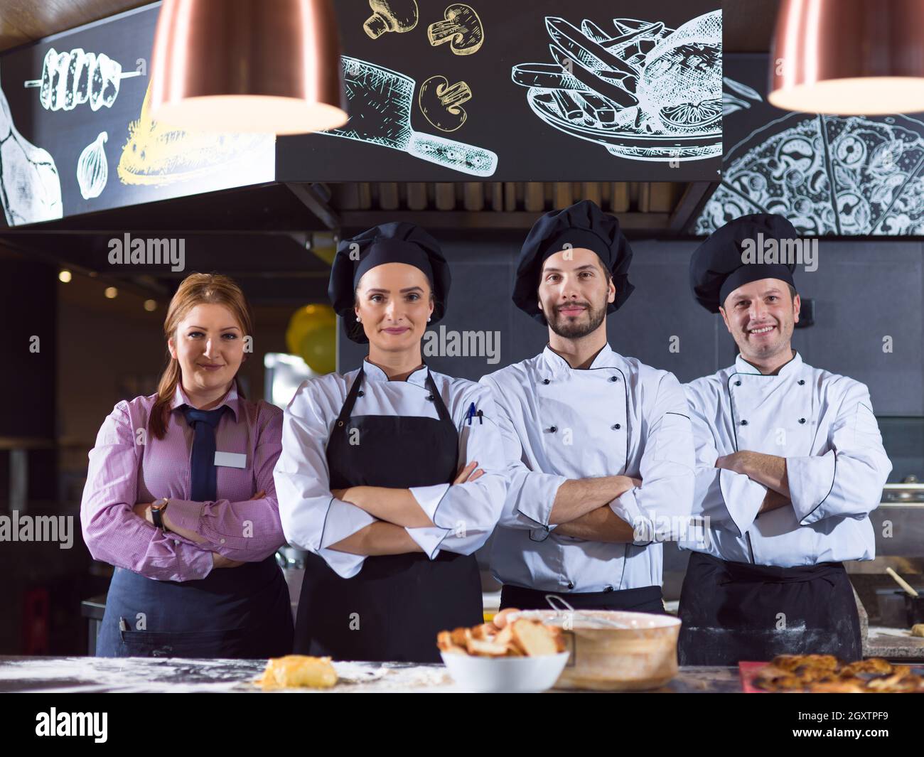 Portrait of group chefs standing together in commercial kitchen at ...