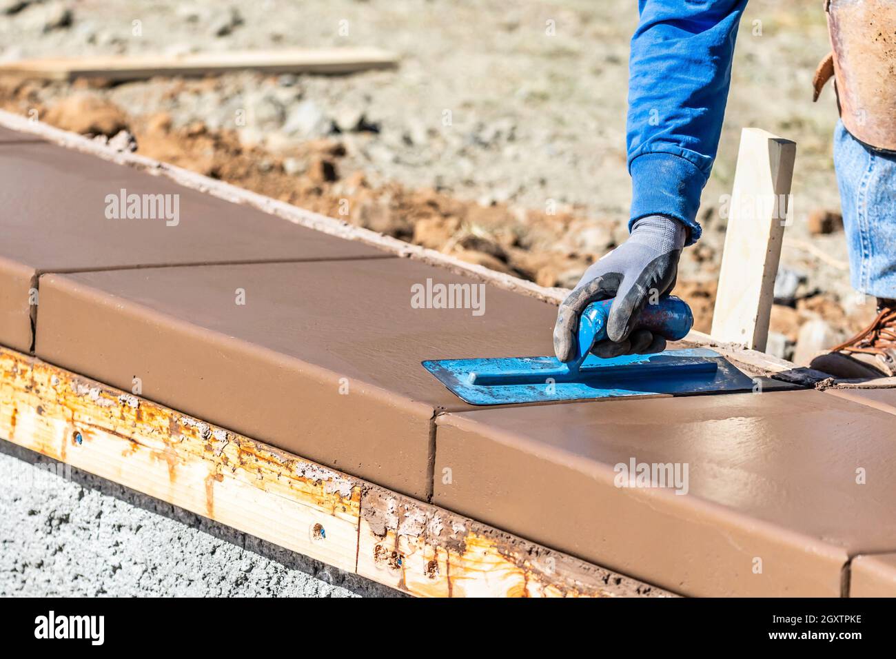 Construction Worker Using Trowel On Wet Cement Forming Coping Around ...
