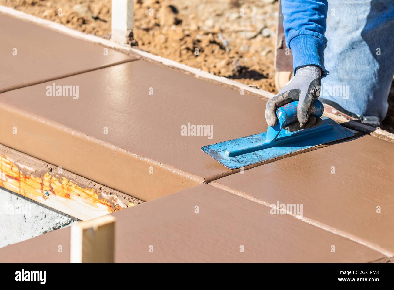 Construction Worker Using Trowel On Wet Cement Forming Coping Around ...