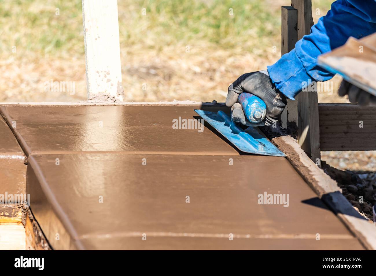 Construction Worker Using Trowel On Wet Cement Forming Coping Around ...