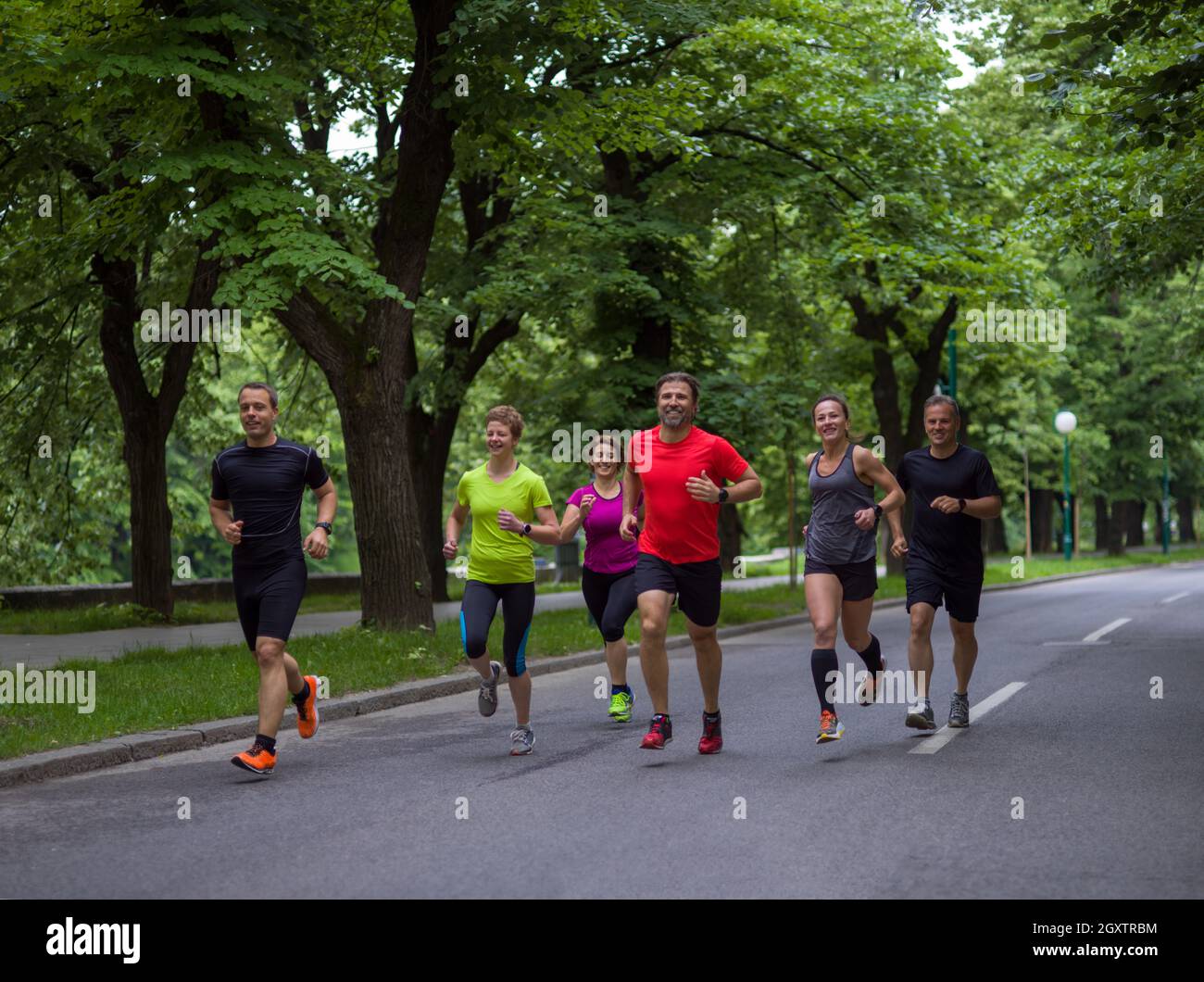 group of healthy people jogging in city park, runners team on morning ...