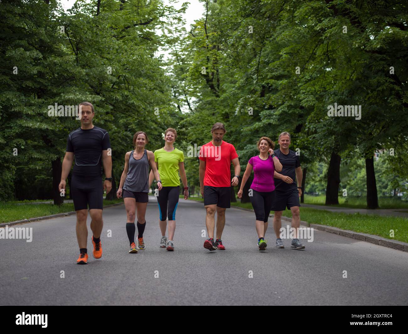 group of healthy people jogging in city park, runners team on morning ...