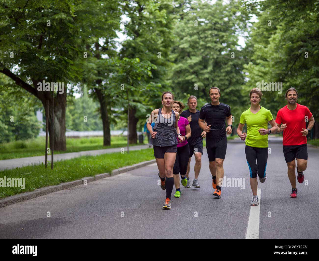 group of healthy people jogging in city park, runners team on morning ...