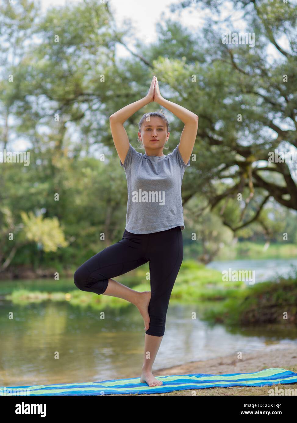 healthy woman relaxing while meditating and doing yoga exercise in the ...
