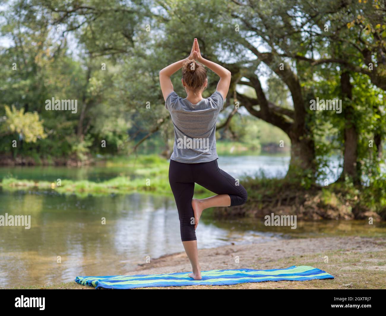 healthy woman relaxing while meditating and doing yoga exercise in the ...