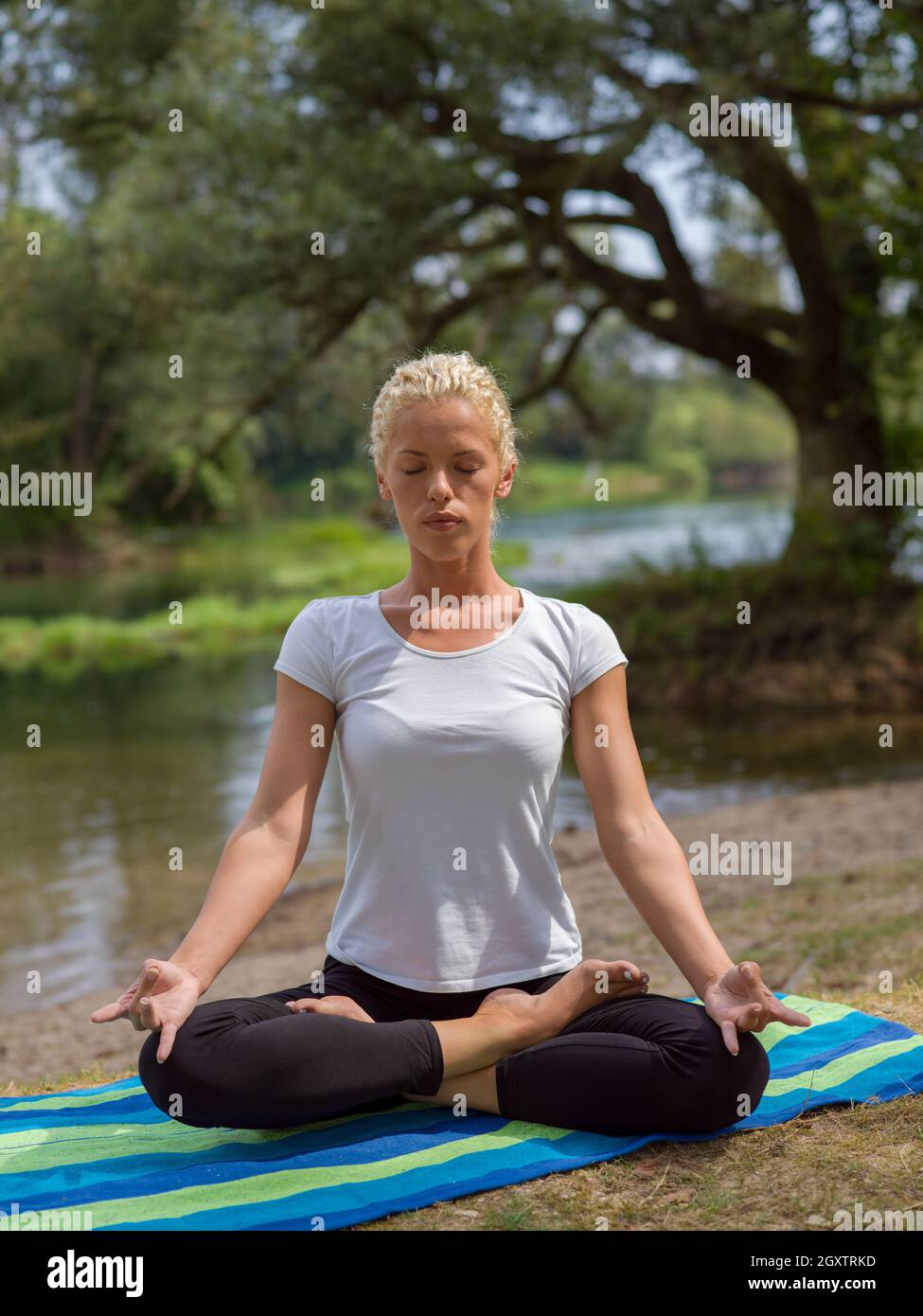 healthy woman relaxing while meditating and doing yoga exercise in the ...