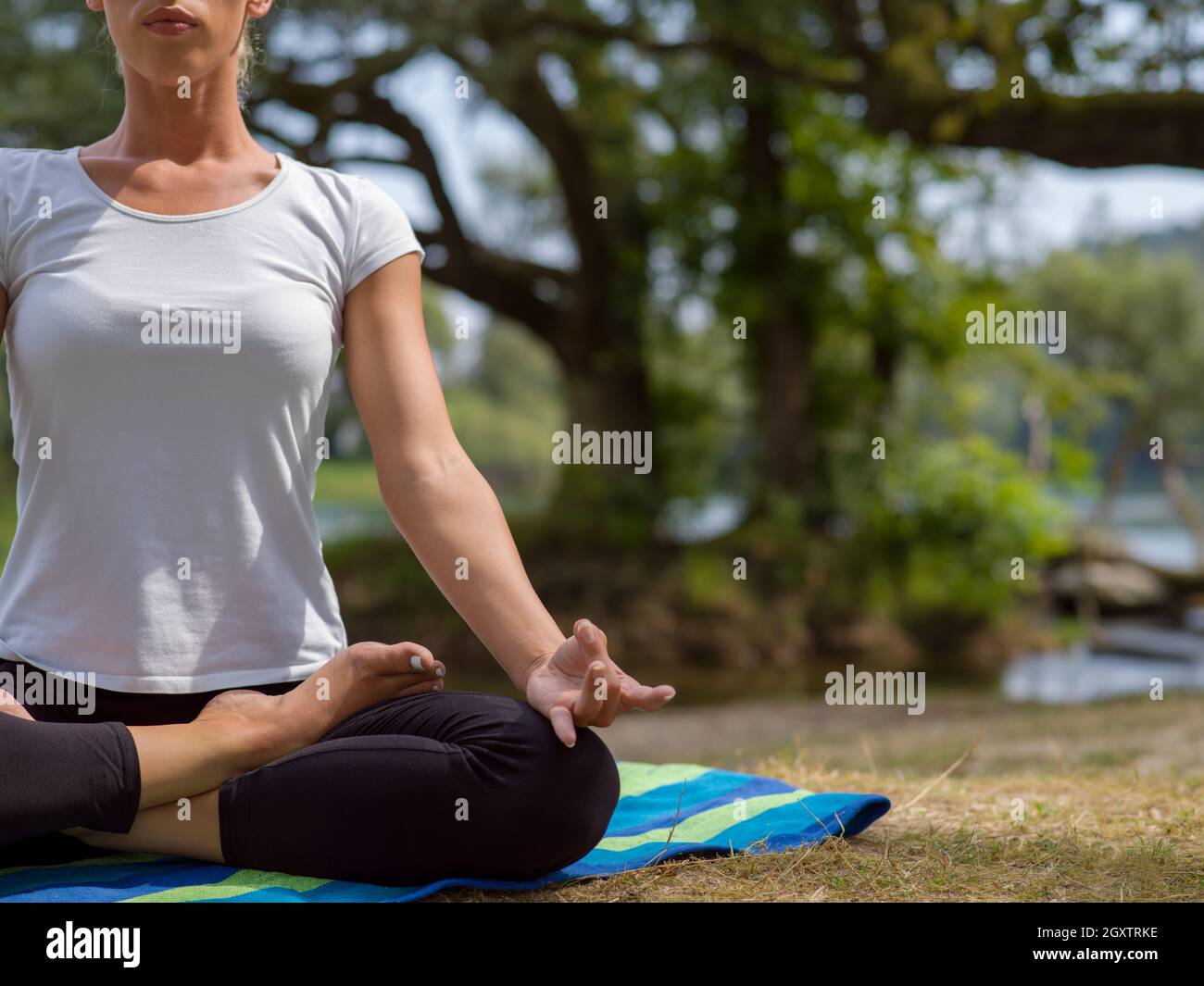 healthy woman relaxing while meditating and doing yoga exercise in the ...