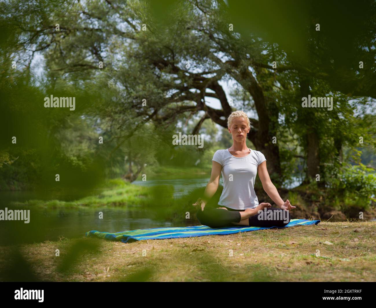 healthy woman relaxing while meditating and doing yoga exercise in the ...